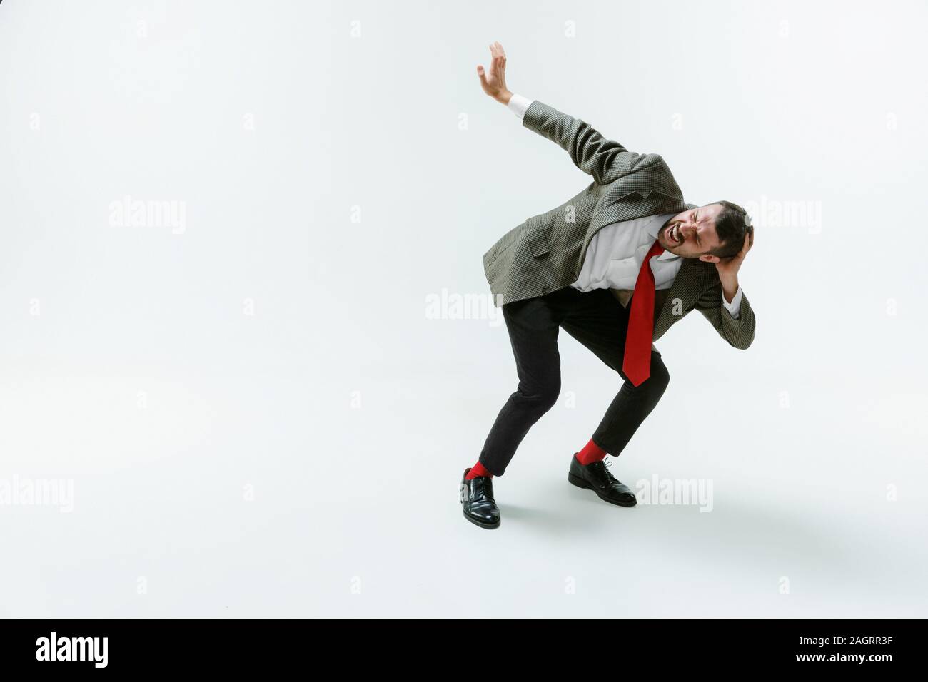 Young caucasian man moving flexible on white studio background. Male ...