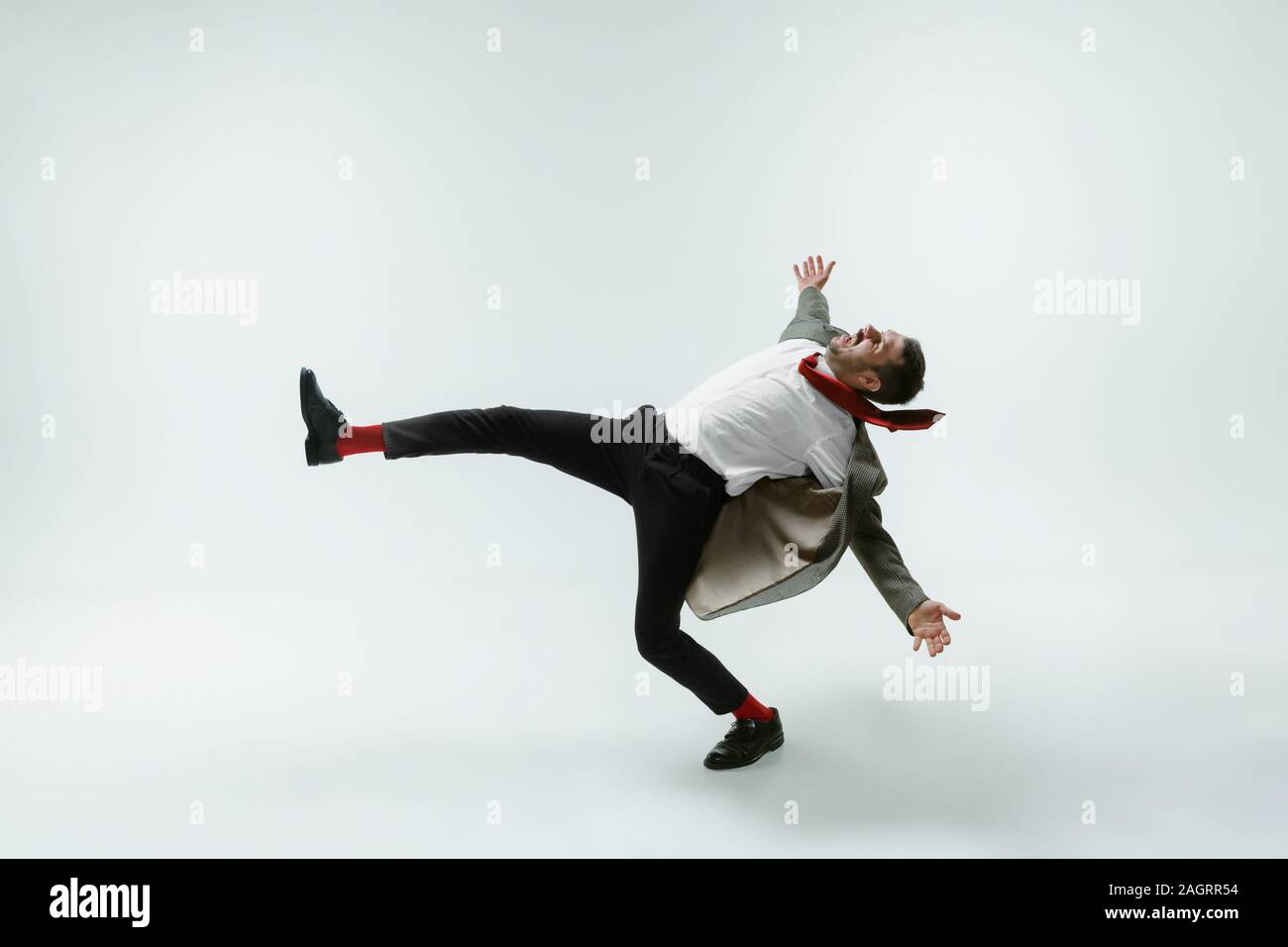 Young caucasian man moving flexible on white studio background. Male ...