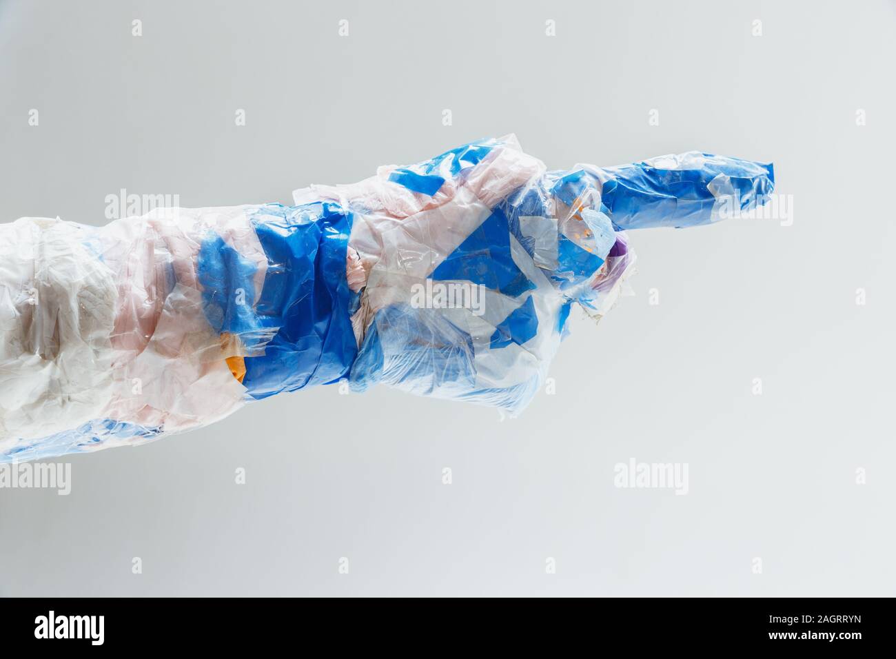 Big plastic hand made of garbage isolated on white studio background ...
