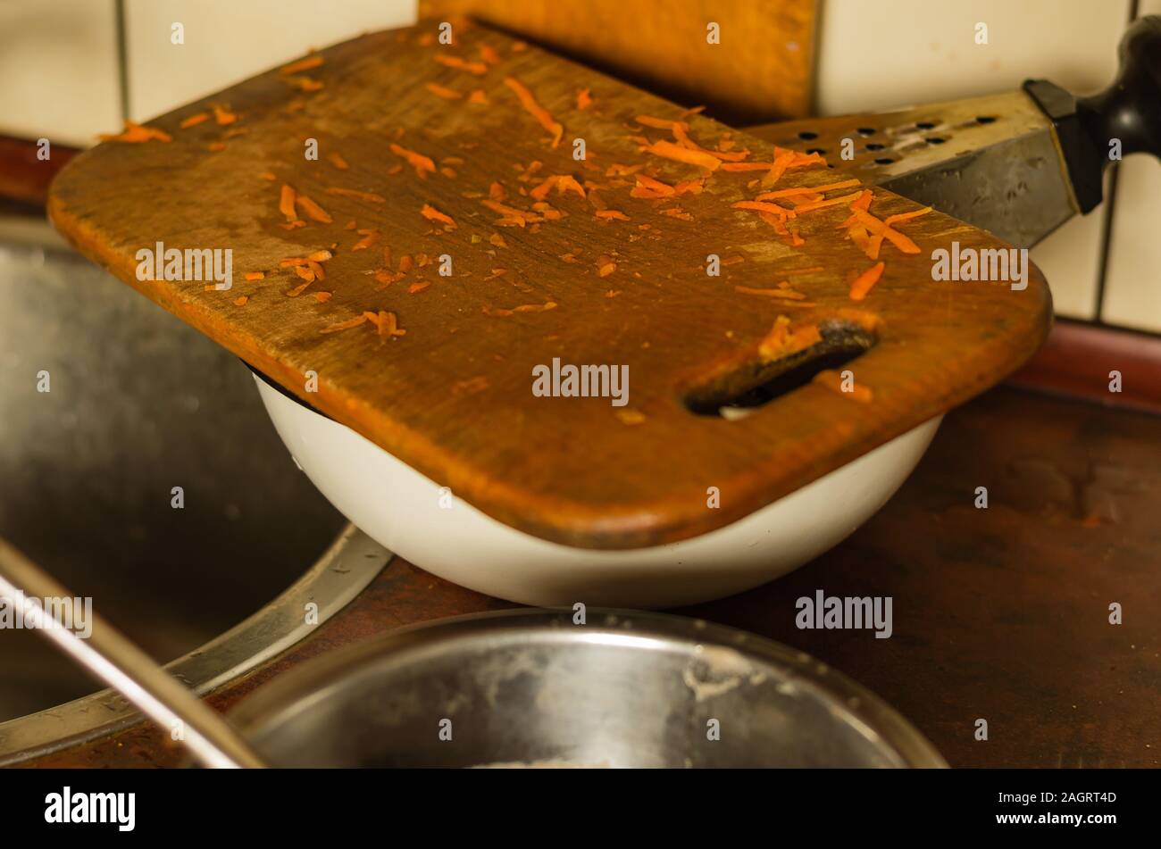 Dirty cutting board next to the sink. Dirty unwashed dishes after ...
