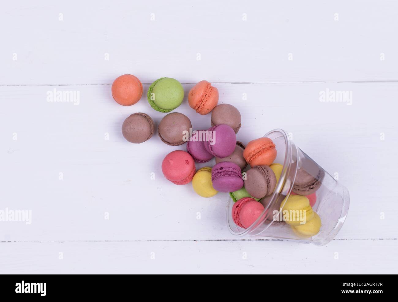 Colorful mini macarons a scattering of packaging on white background ...