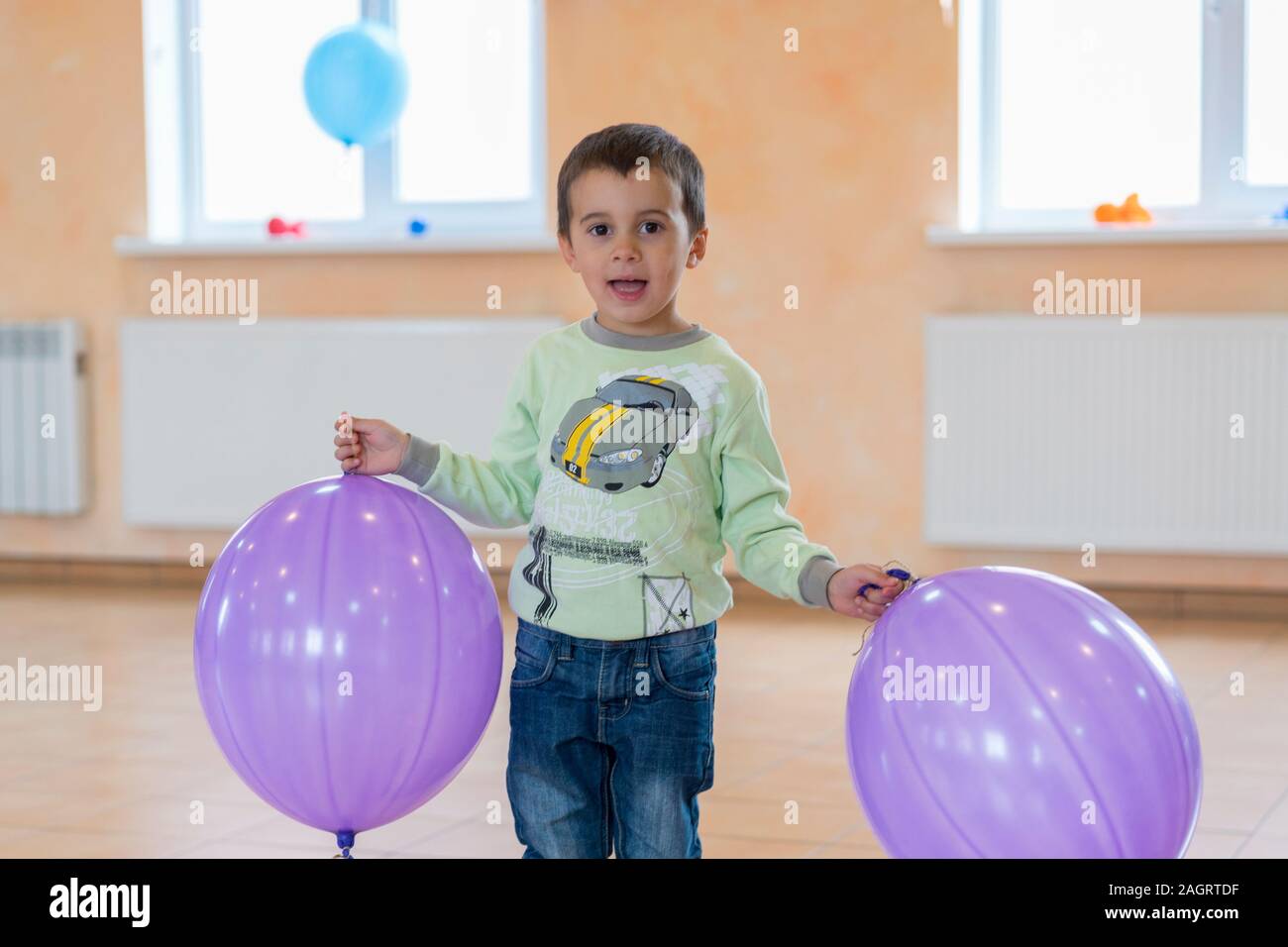 Little boy with big balloons. Happy kid with purple balloons in the ...