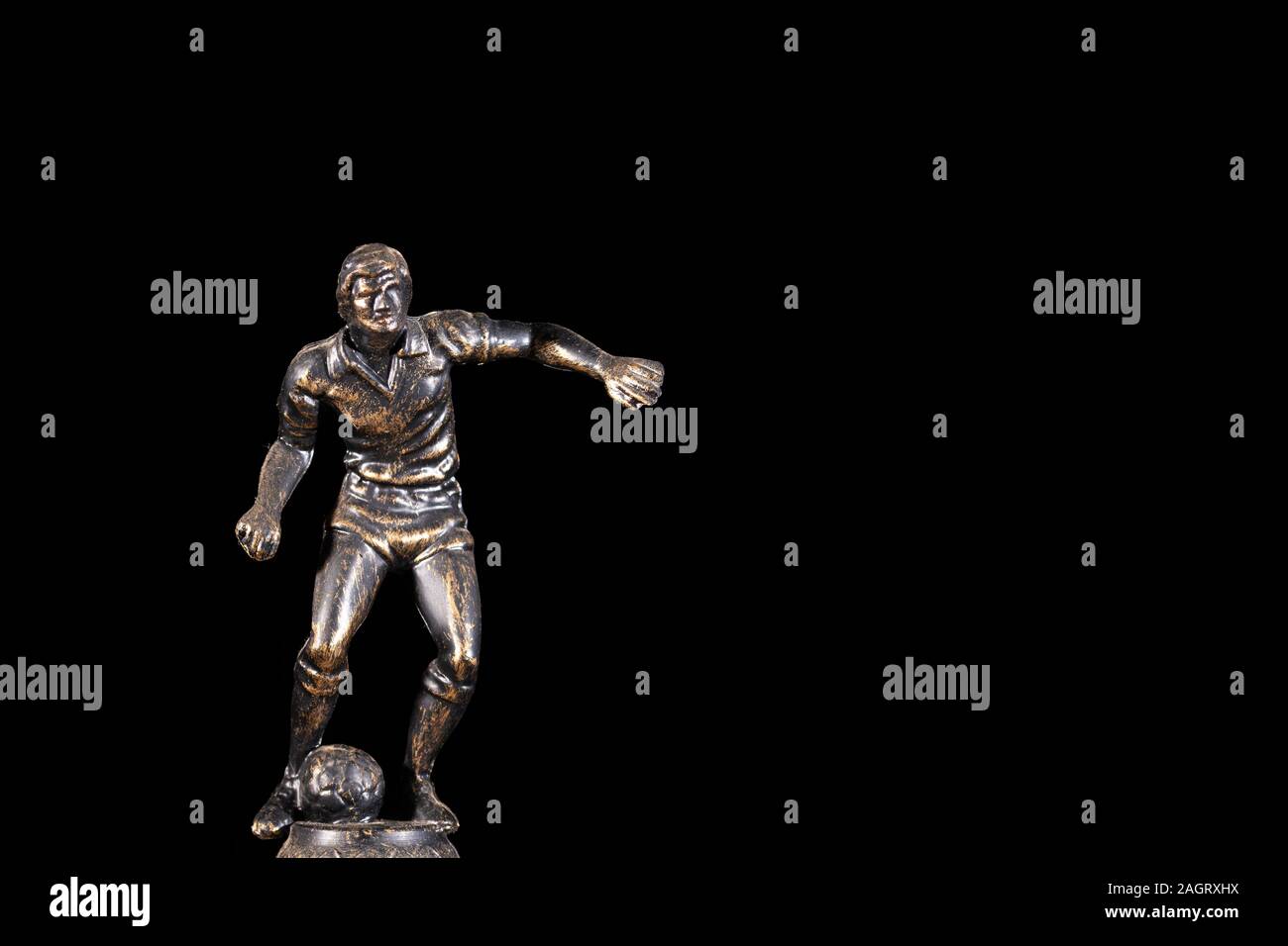 A silver trophy of a football (soccer) player with gold accents on a ...