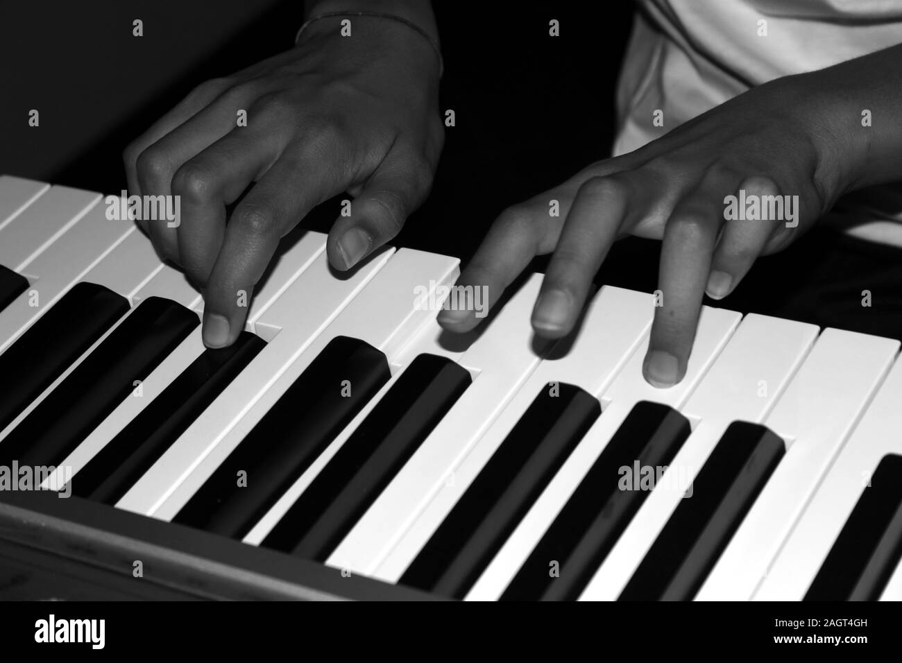 two hands playing music on the keyboard Stock Photo - Alamy