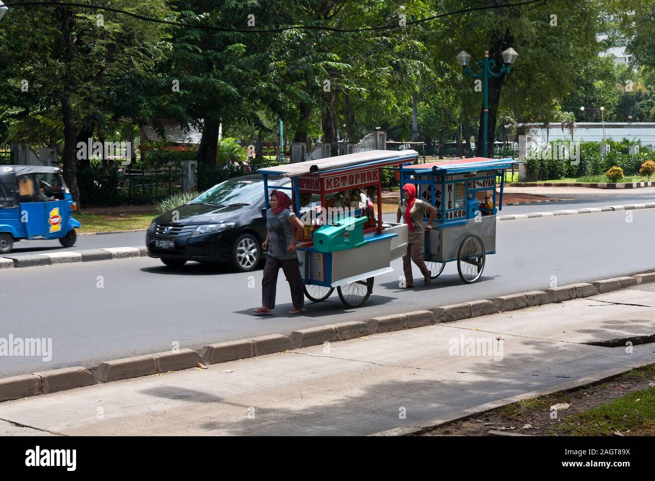 Indonesian women moving mobile street food stalls on the street Stock ...