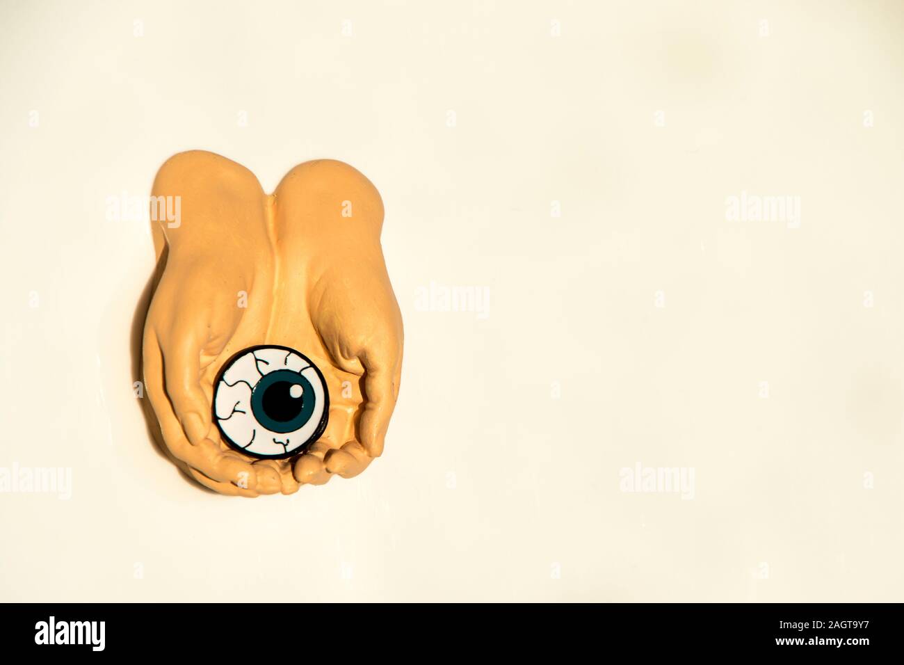 A pair of cupped hands hold and care for an eye, to signify looking ...