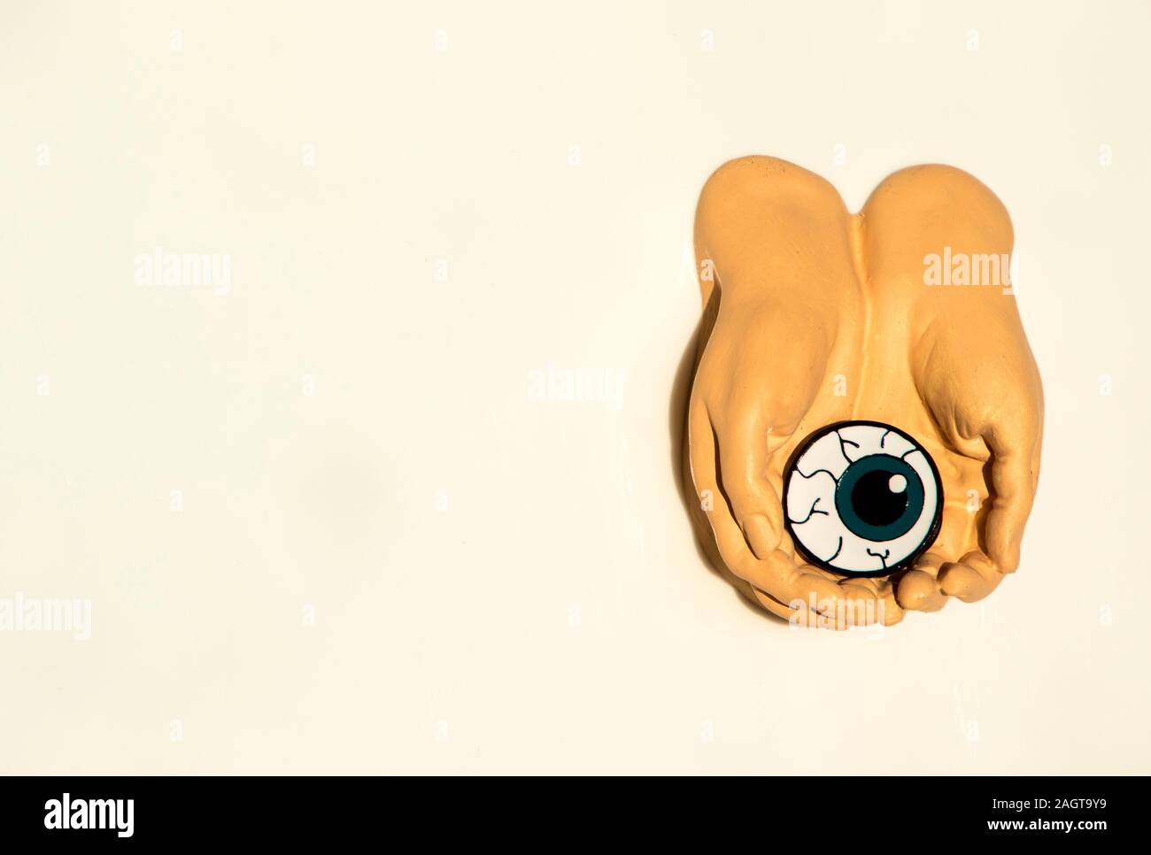 A pair of cupped hands hold and care for an eye, to signify looking ...