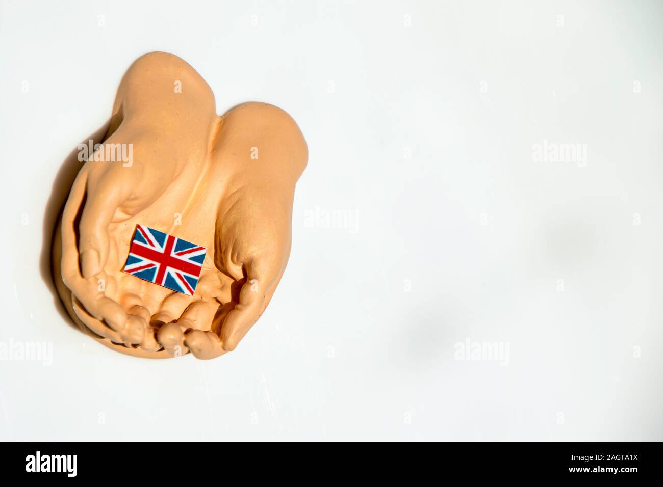 A pair of cupped hands hold and care for the Union Jack flag Stock ...