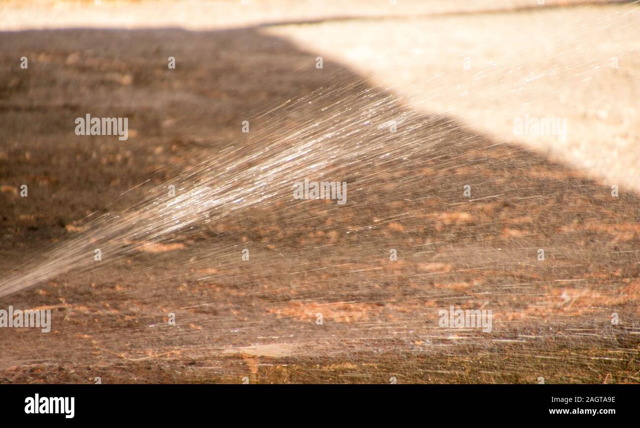 A water spray system jets out water to an area of grass to keep it ...