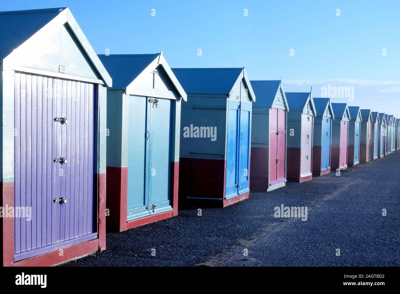 A line of fifteen colourful beach huts with a diminishing perspective ...