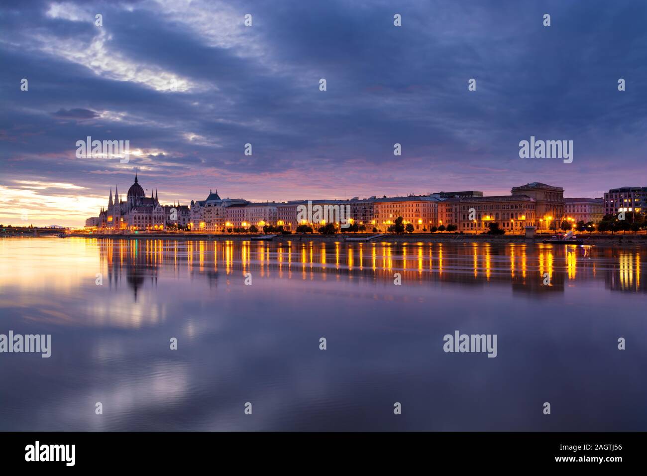 Night view of illuminated Budapest riverfront reflecting in the river ...