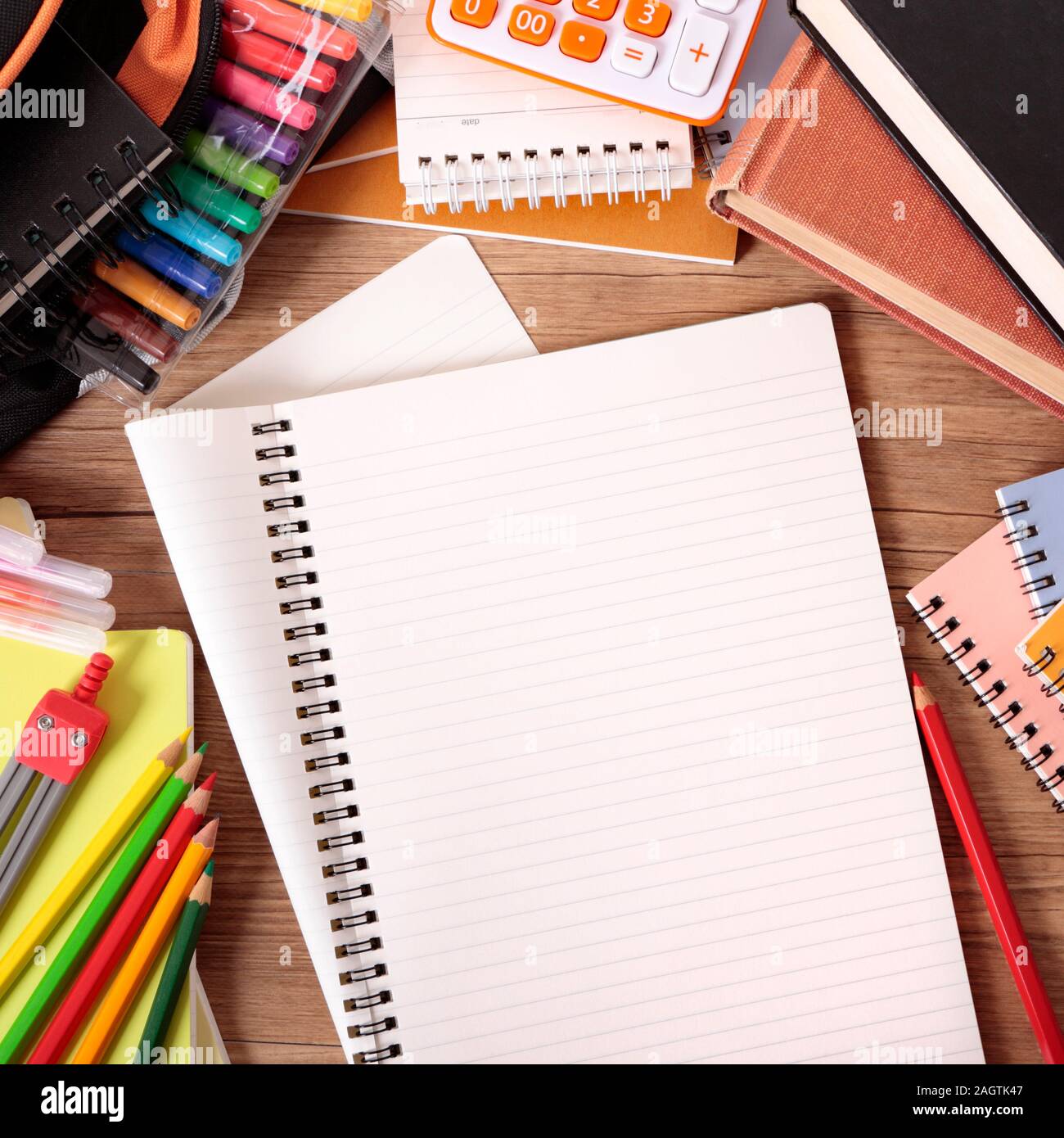 Busy student's desk with open notebook, school bag, text books and ...