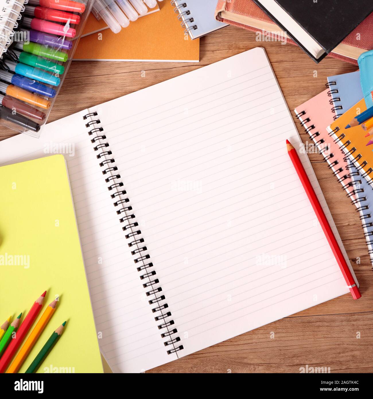 Busy student's desk with open notebook, school bag, text books and ...
