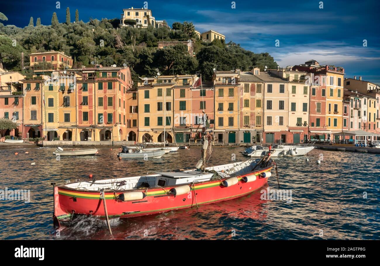 Small red fishing boat in Portofino harbor against a backdrop of ...