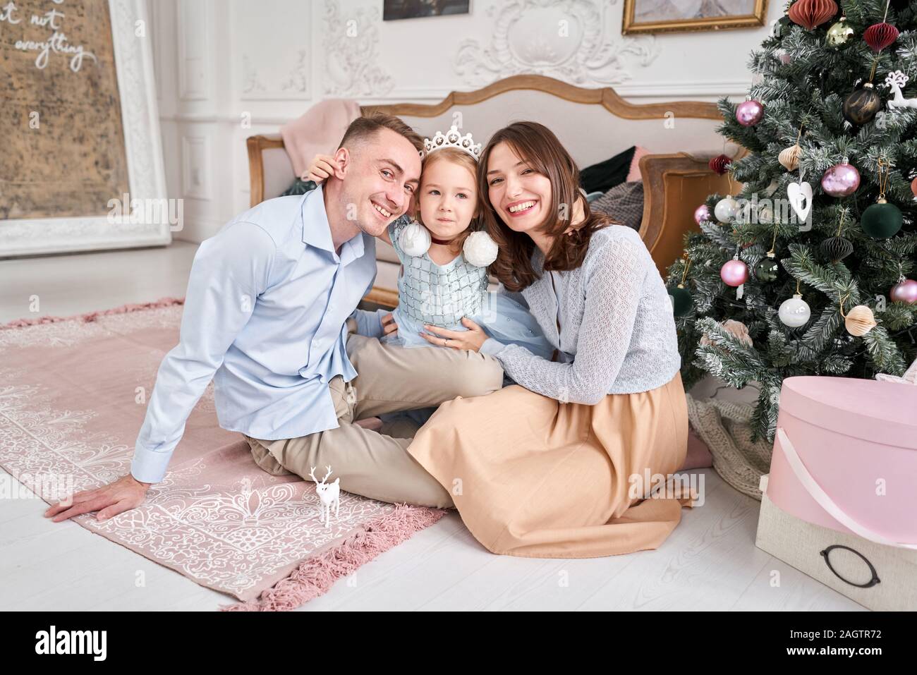 Loving family. Mom and dad hugging little daughter . Parents and baby child having fun near ...