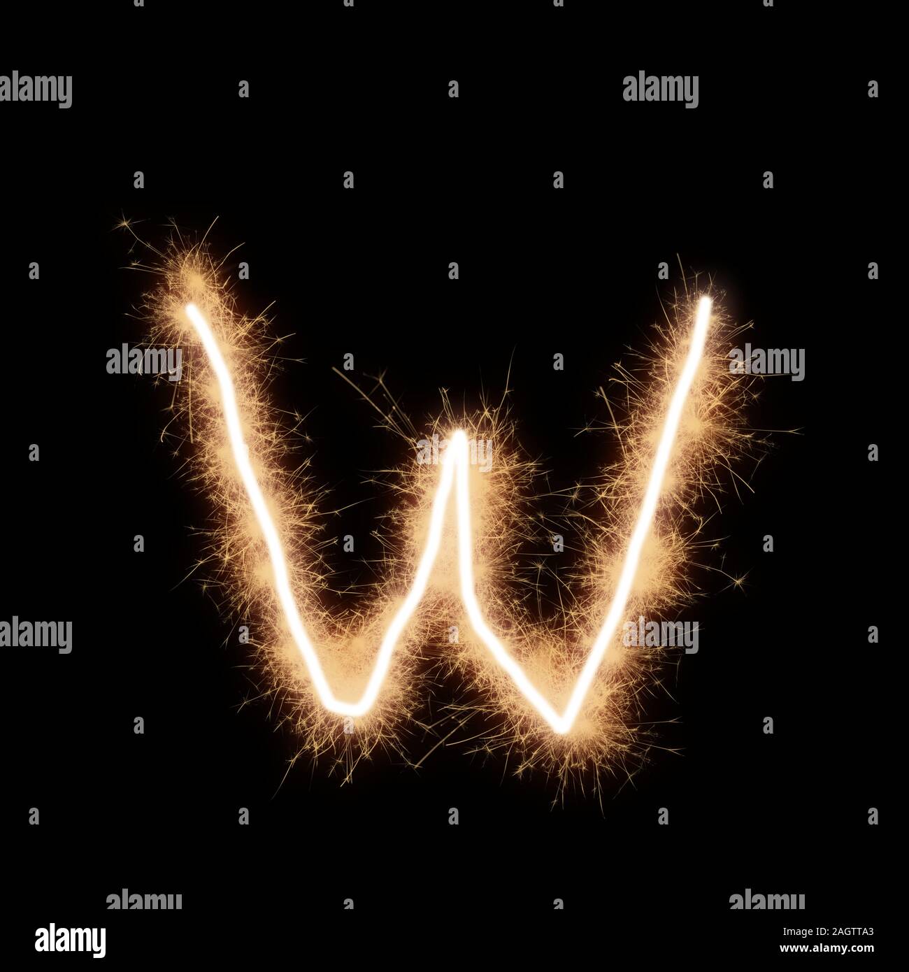 Lower case w letter of alphabet written by squib sparks on a black ...