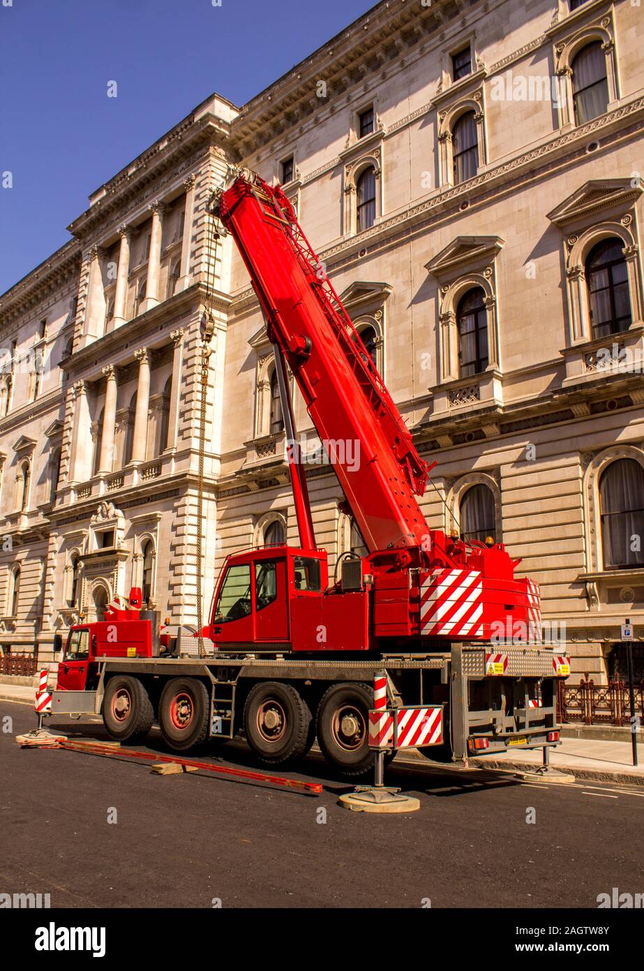 A huge red crane operates in the middle of an area of London city Stock ...