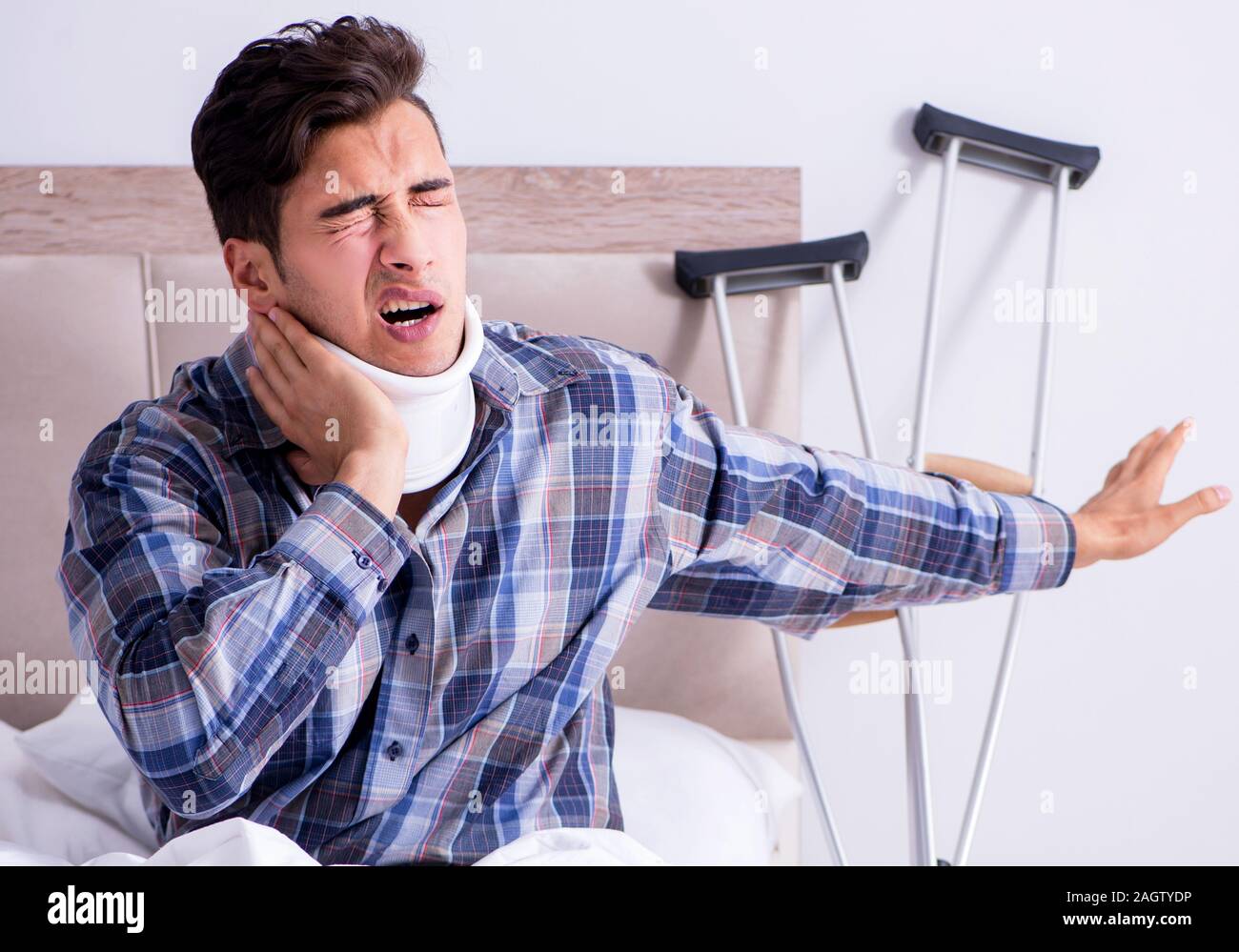 The injured man in bed at home with crutches Stock Photo - Alamy