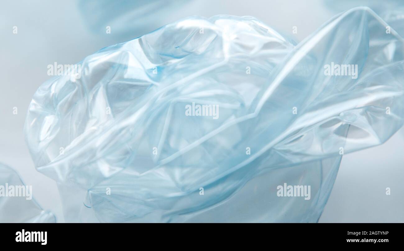 A collection of plastic bottles crushed and displayed on a white ...