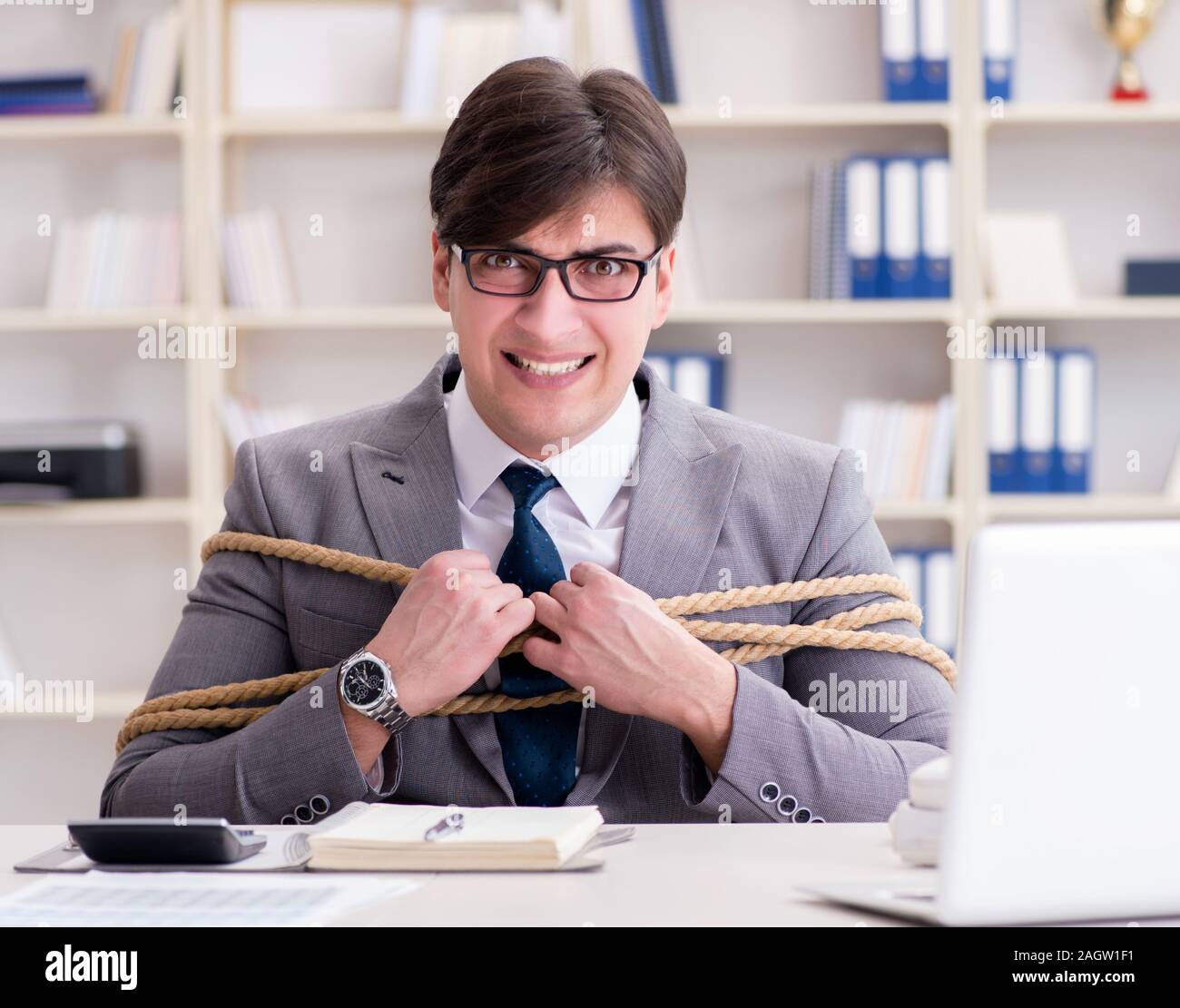 The businessman tied up with rope in office Stock Photo - Alamy