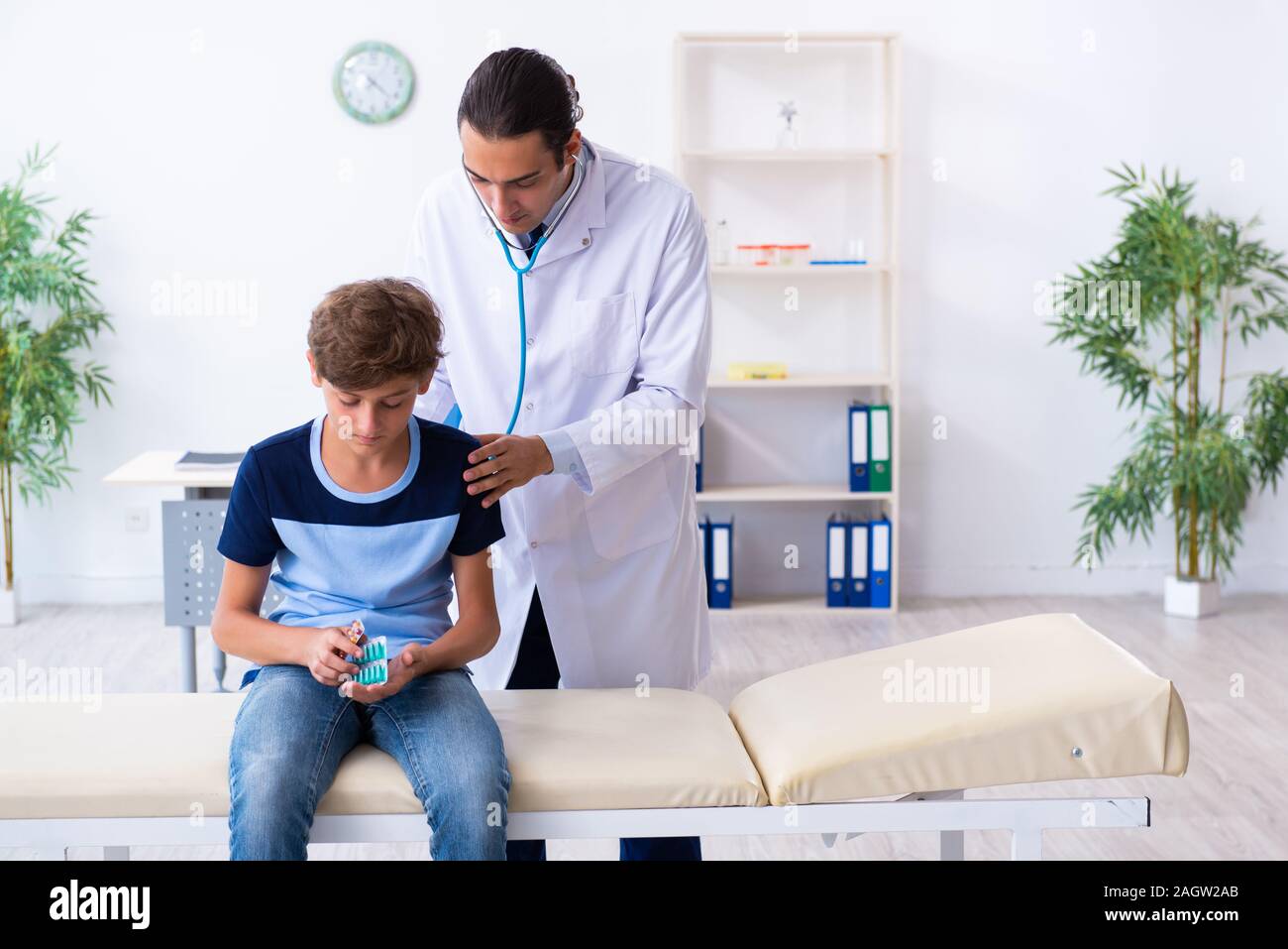 The young male doctor examining boy in the clinic Stock Photo - Alamy