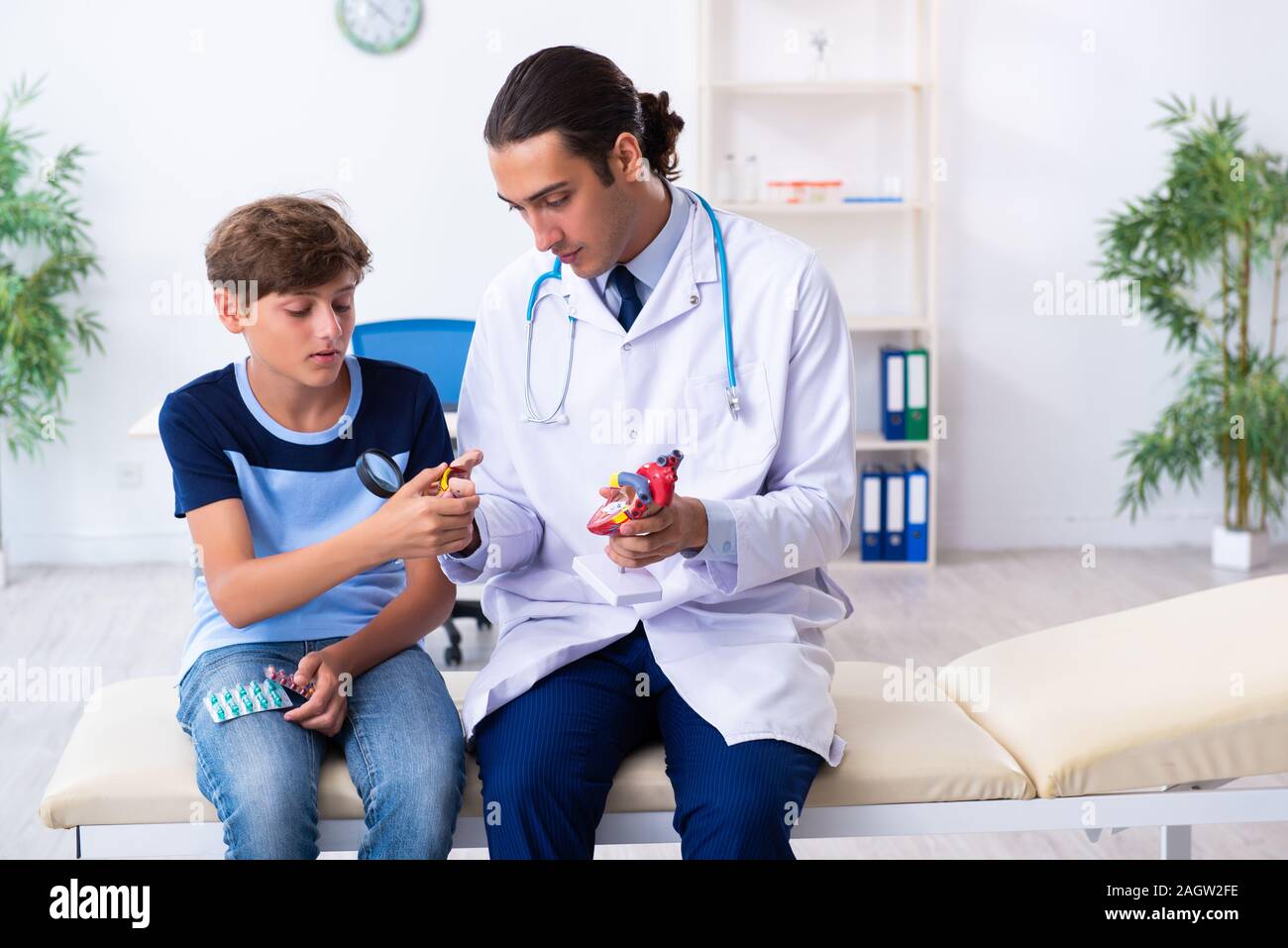 The young male doctor examining boy in the clinic Stock Photo - Alamy
