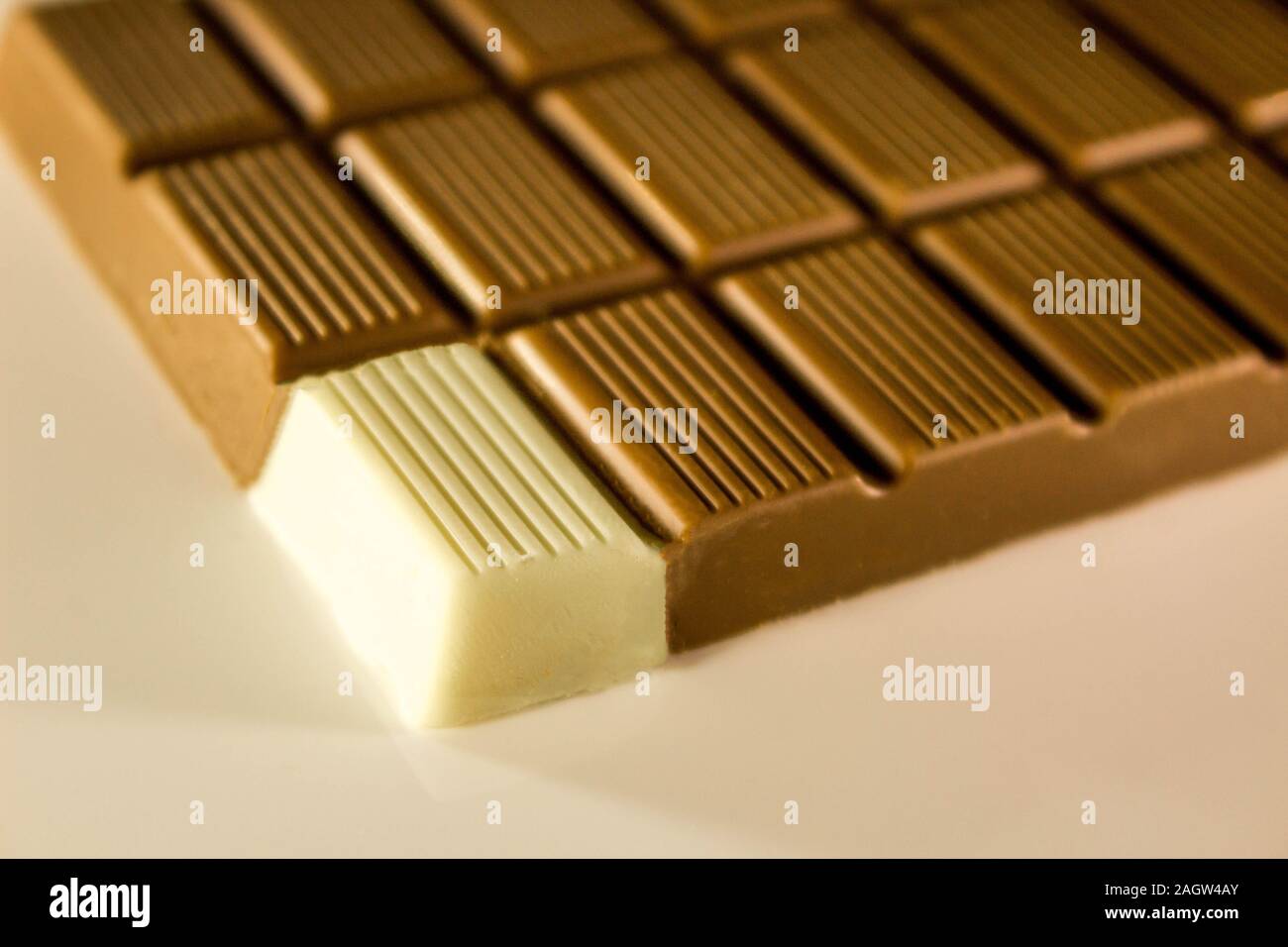 A bar of brown chocolate with just one square of white chocolate on the ...