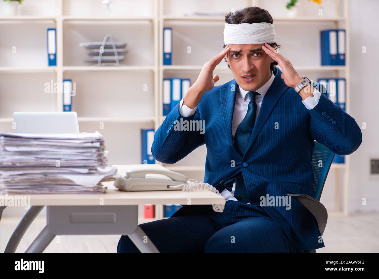 The head injured male employee working in the office Stock Photo - Alamy