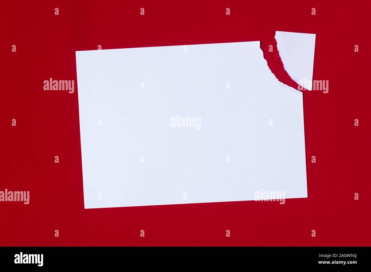 White sheet of paper with a broken piece on a red background Stock ...