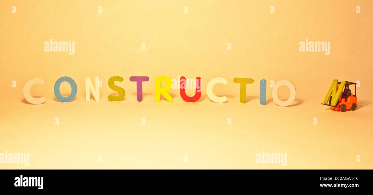 The word 'Construction' being made up from wooden coloured letters ...