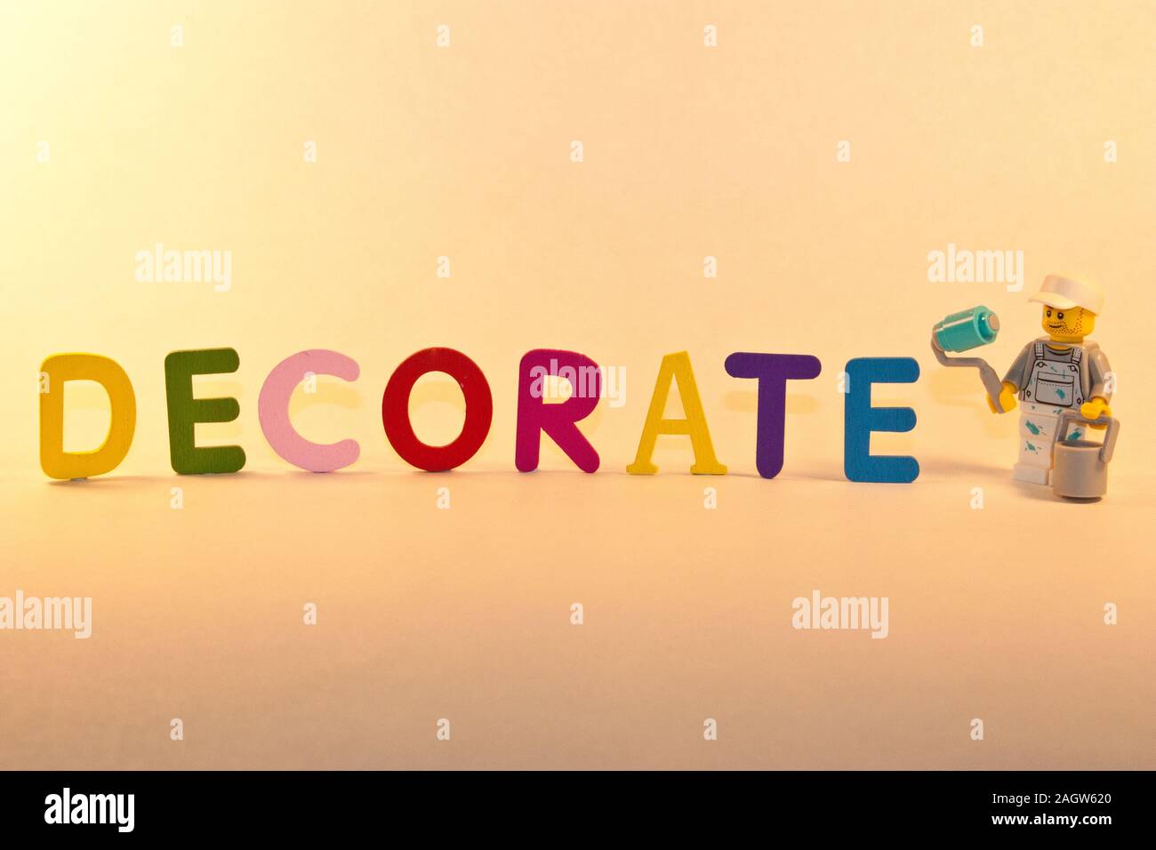A painter stands beside colourful letters to show the word 'Decorate ...