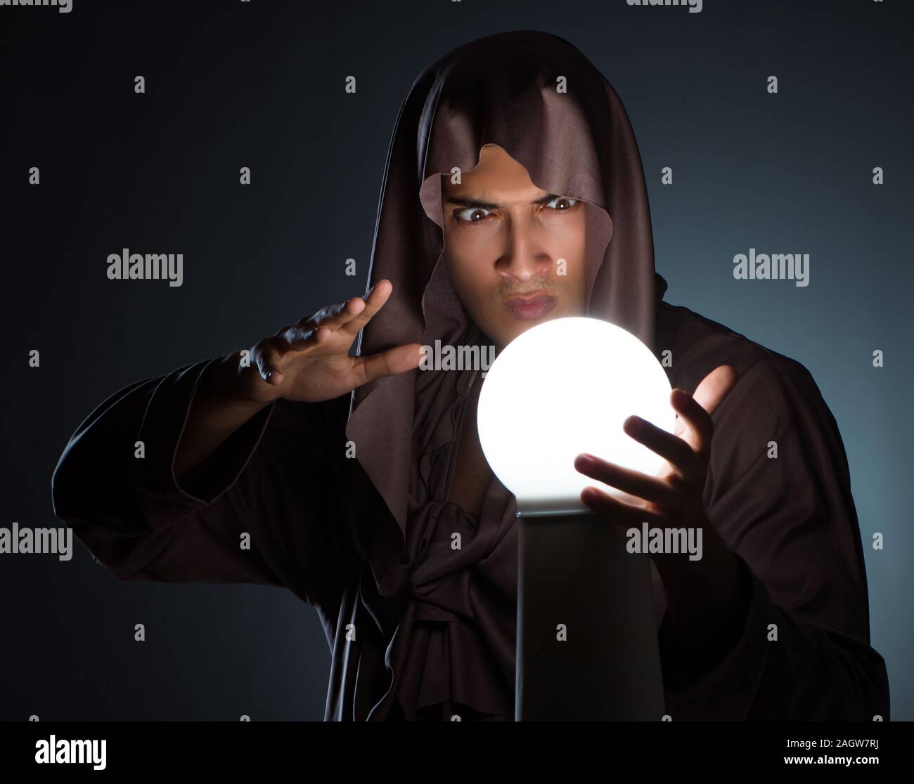 The young wizard with crystal ball in dark room Stock Photo - Alamy