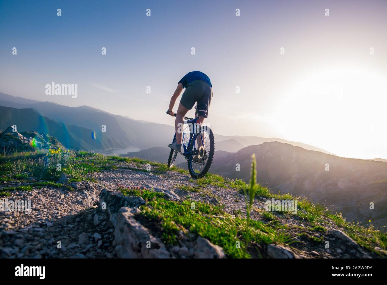 Adventurous Cyclist riding his mountain bike at the edge of a cliff, on ...