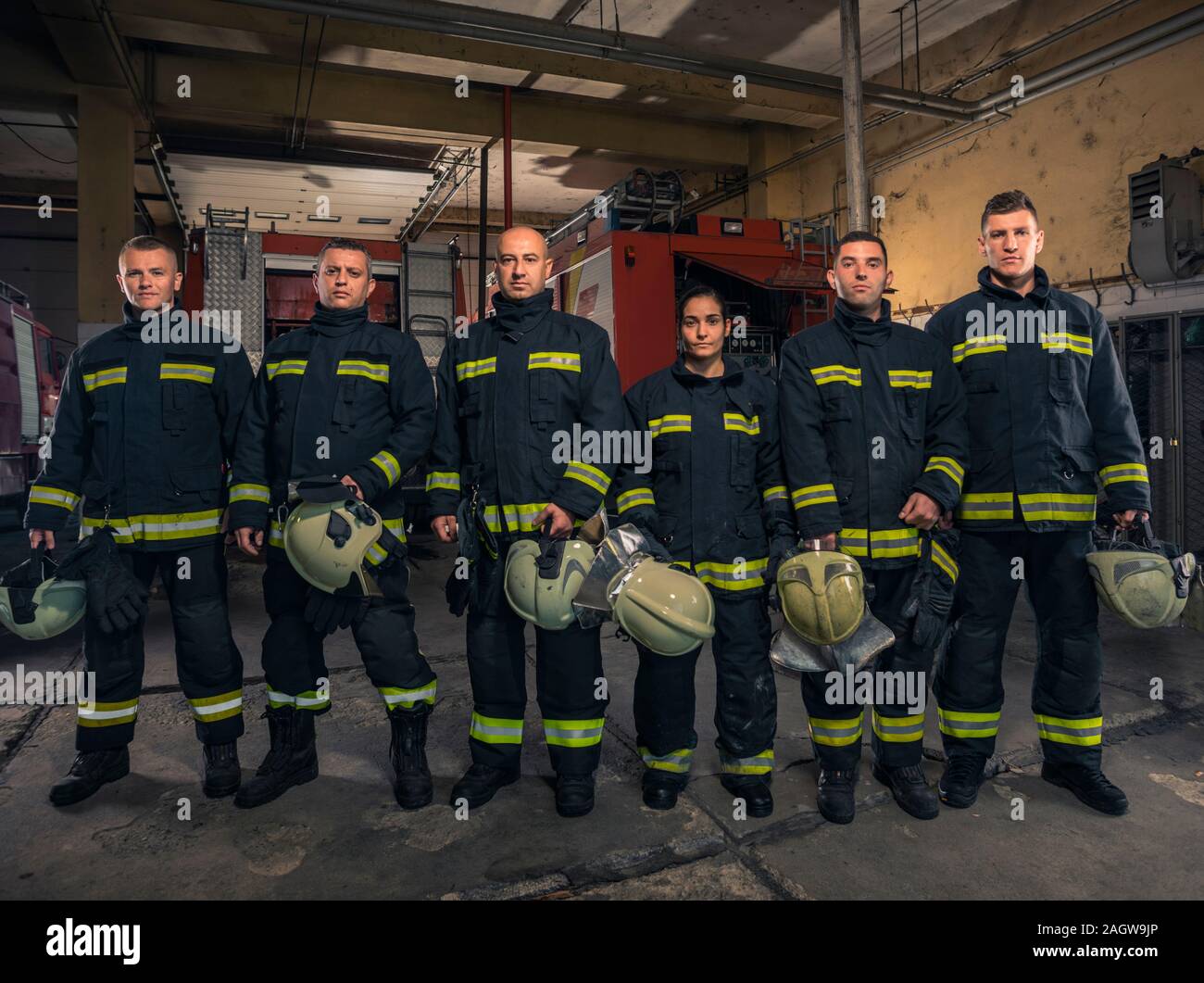 Portrait of firefighters standing by a fire engine Stock Photo - Alamy