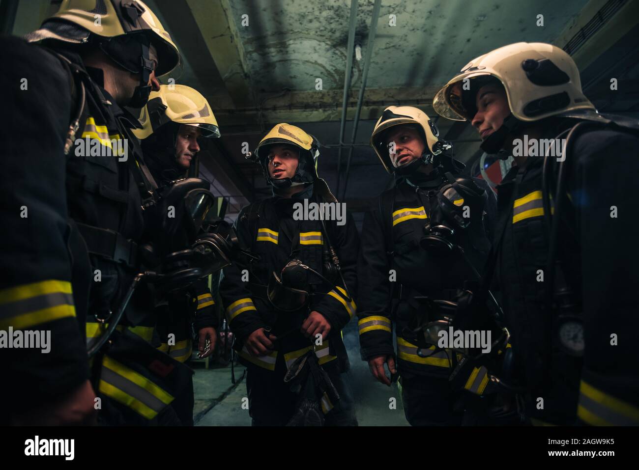 Team of firefighters standing inside ( indoors ) a buliding next to a ...