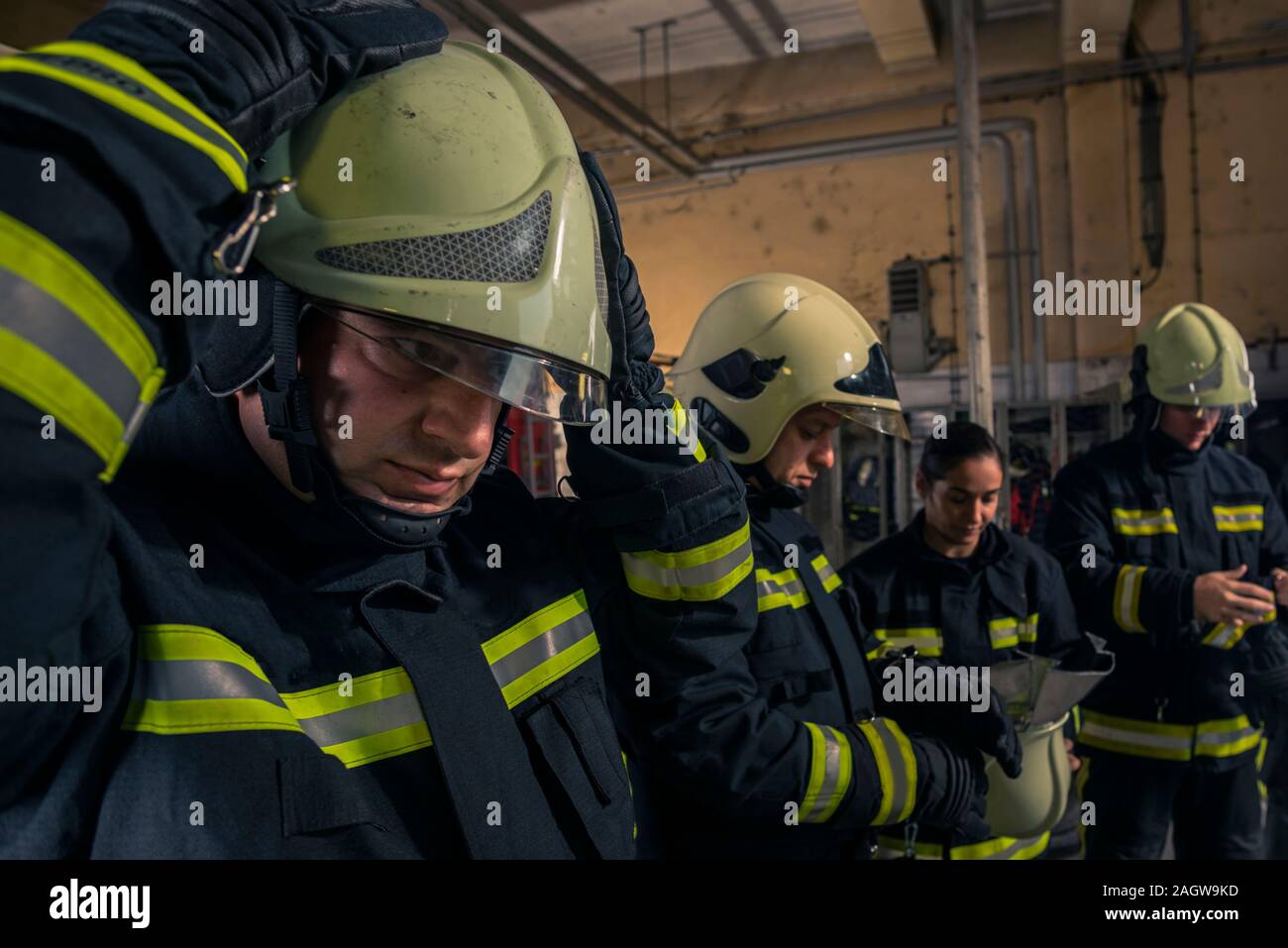 Firemen preparing for emergency service. Firefighters putting on gloves ...