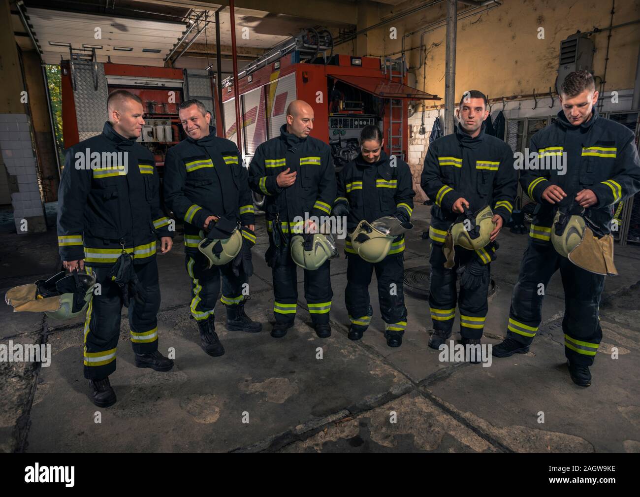 Portrait of firefighters standing by a fire engine Stock Photo - Alamy