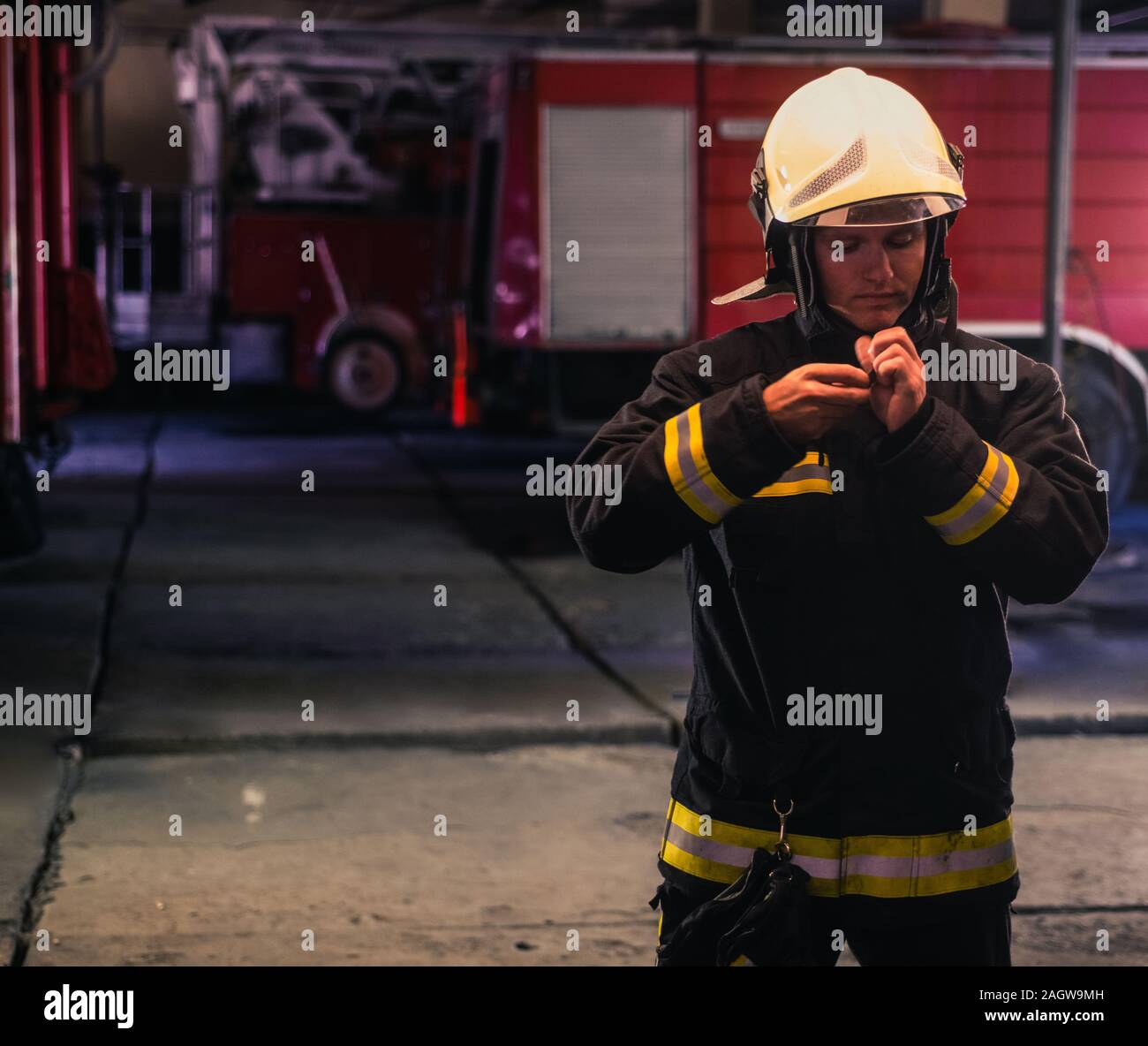 Portrait of young fireman standing inside the fire station Stock Photo ...