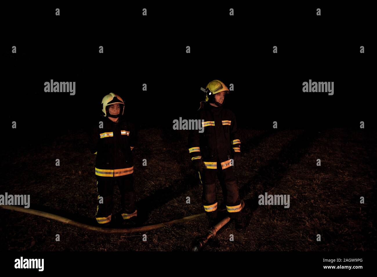 Firefighting group in action battling flames during night time Stock ...