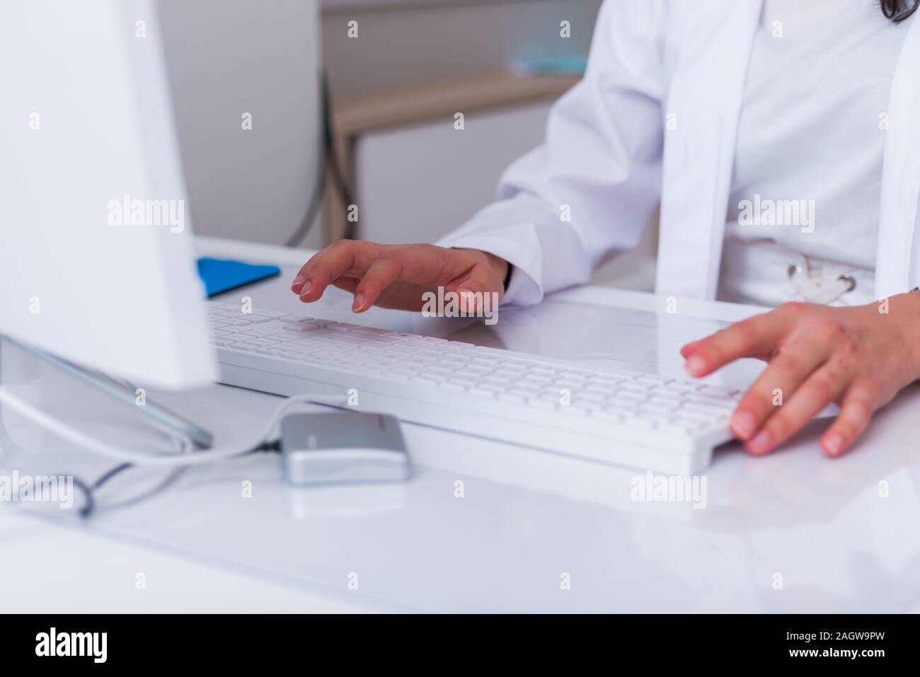 Close up hands of a female physician ( nurse ) typing on her white ...