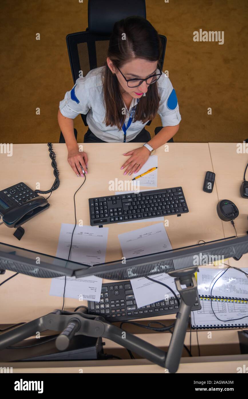 Female security guards working on computers while sitting in the main ...