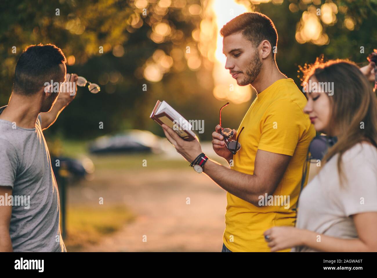 A group of three people in the park are searching for something in the ...