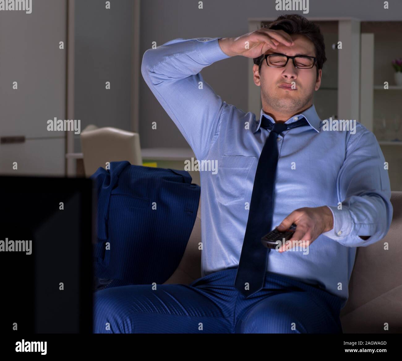 The businessman watching tv at night late Stock Photo - Alamy