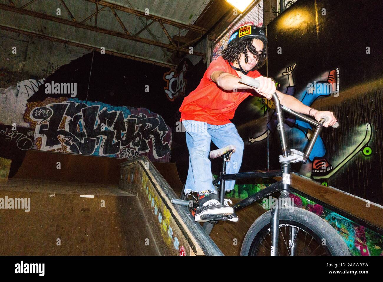 An extreme athlete riding urban BMX at an indoor skate park with lots ...