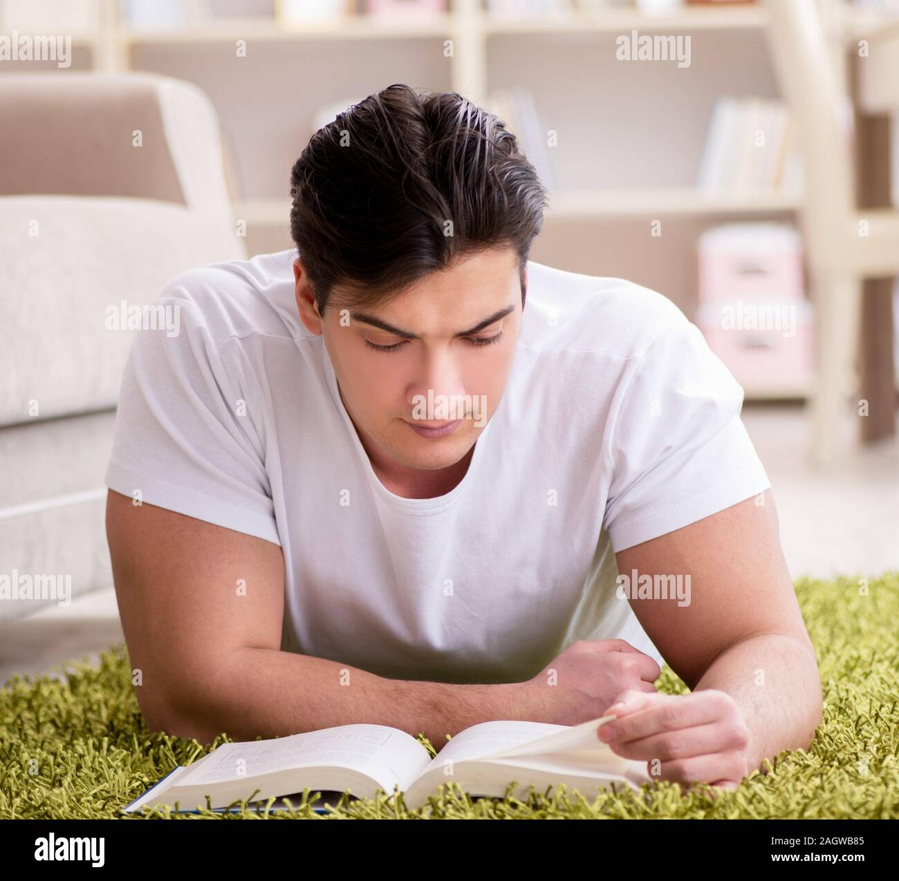 The man reading book at home on floor Stock Photo - Alamy