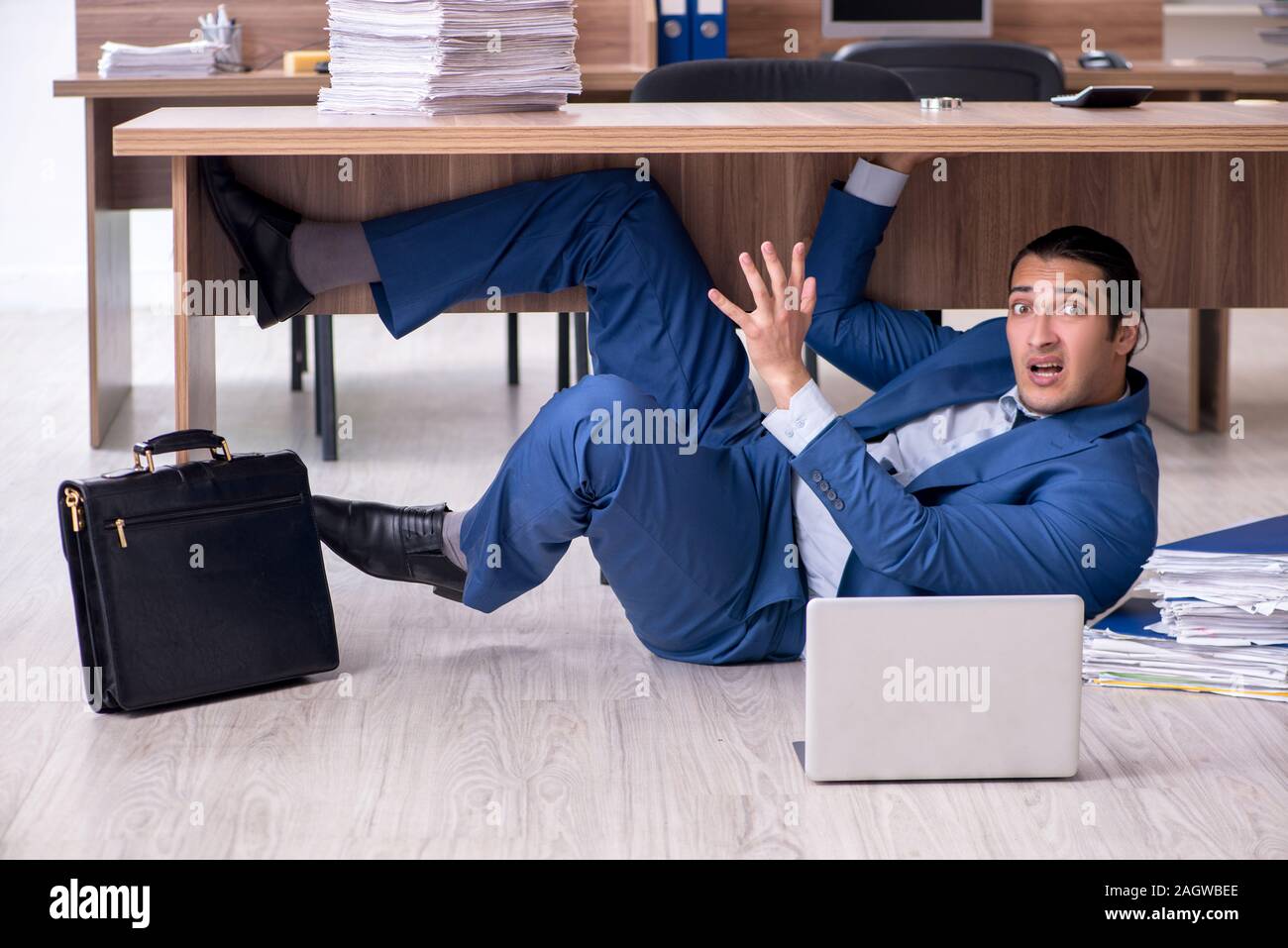 The young male employee and too many work in the office Stock Photo - Alamy