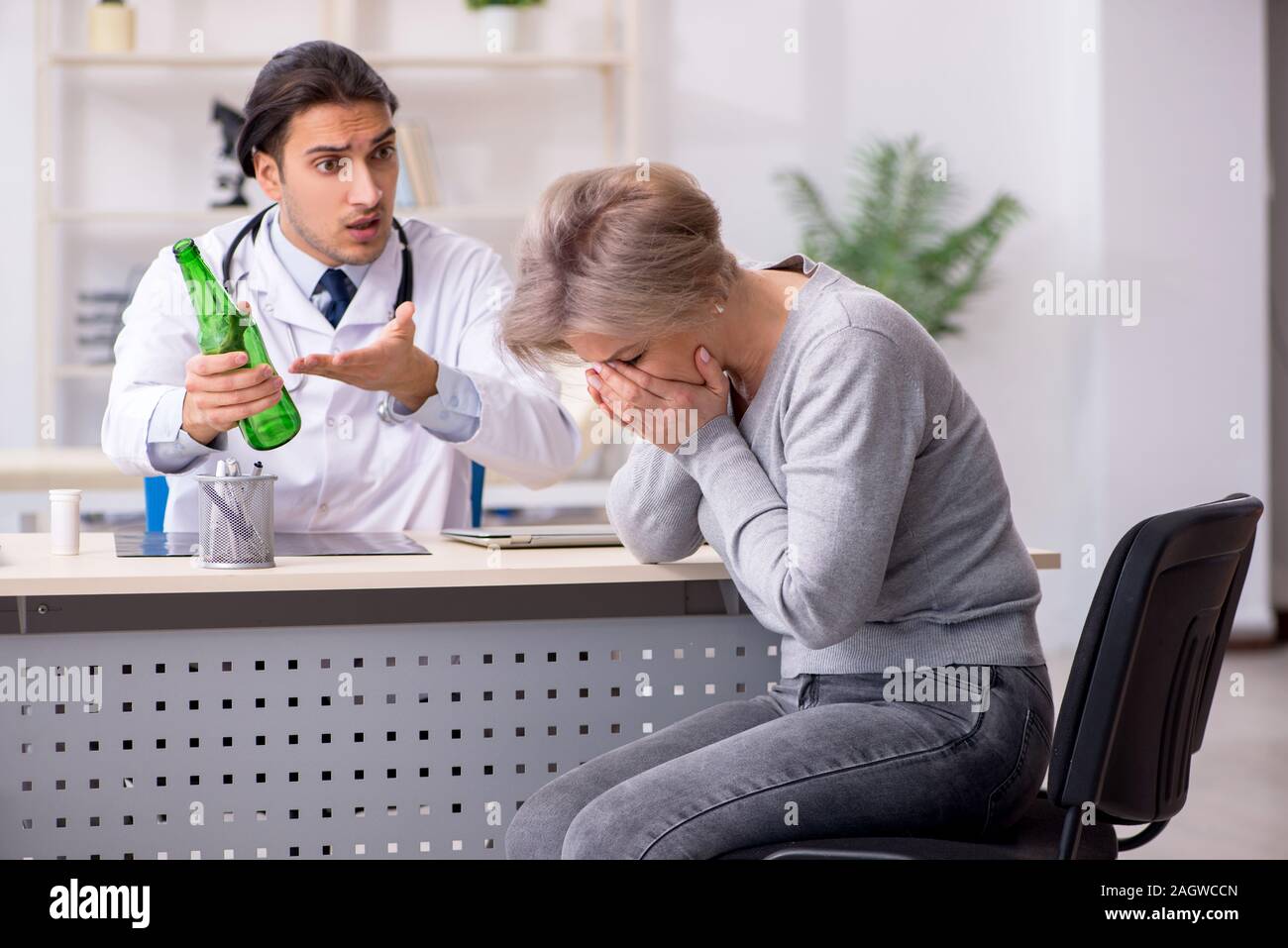 The female alcoholic visiting young male doctor Stock Photo - Alamy
