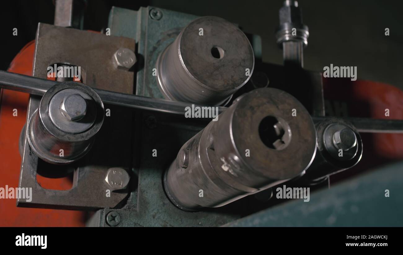 Forge workshop on table. Worker bends the metal rod on the wrought iron ...