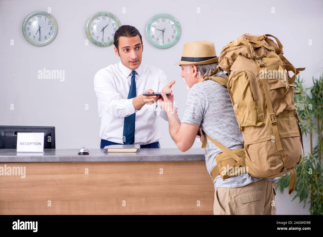 Old backpacker at the hotel reception Stock Photo - Alamy
