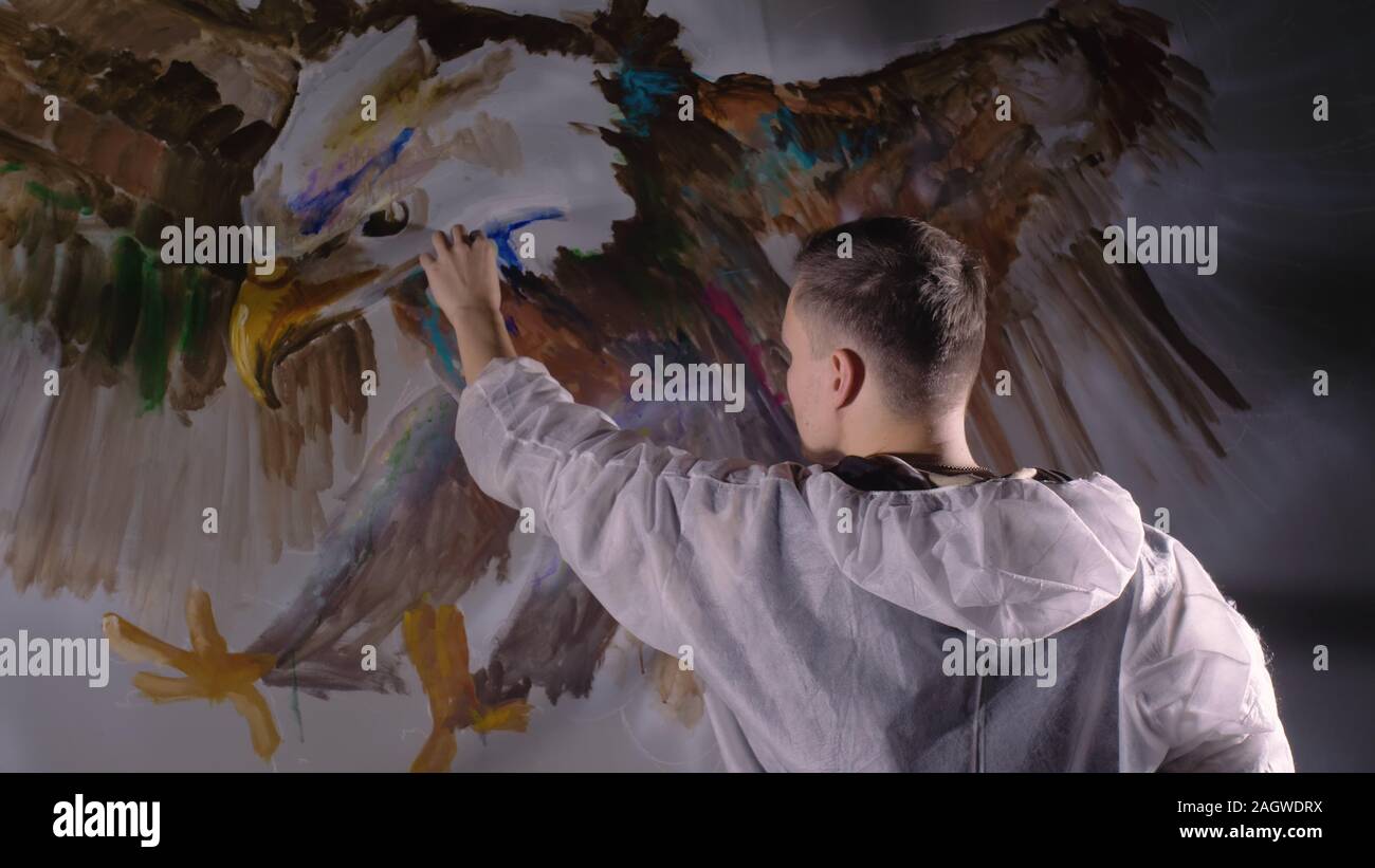 Artist designer draws an eagle on the wall. Craftsman decorator paints ...
